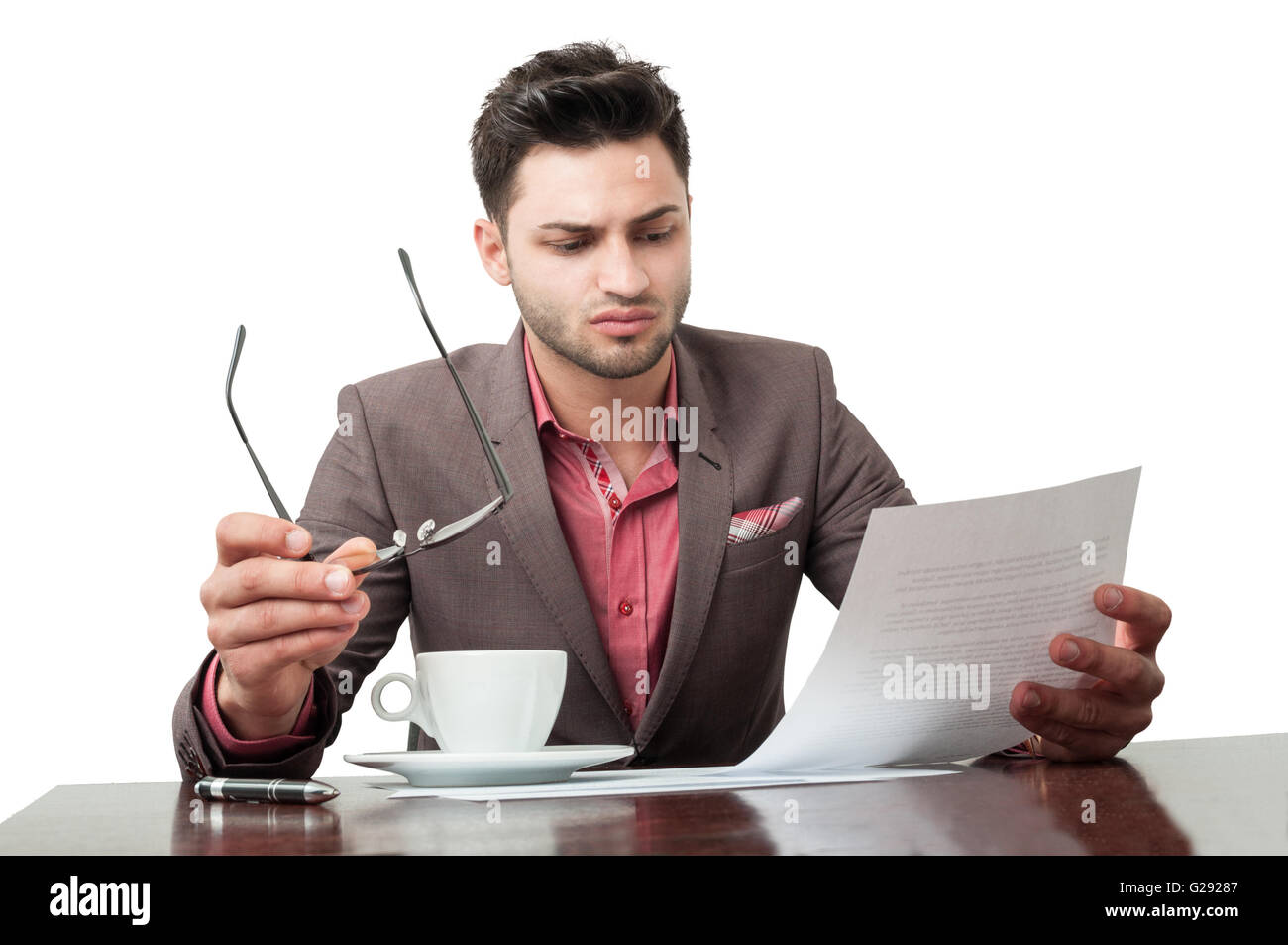 Young and handsome business man reading company documents without using ...