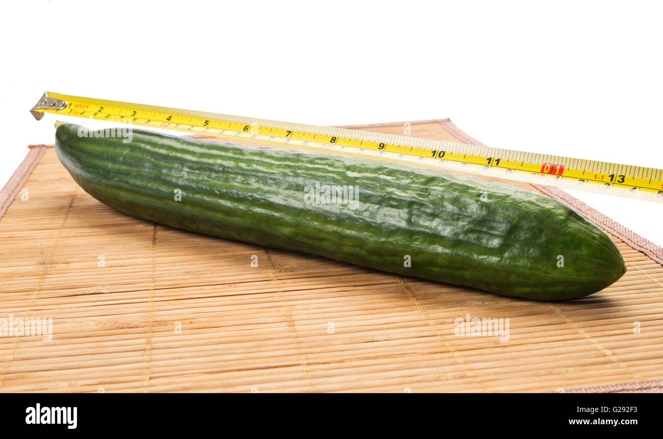 Big yellow centimeter measuring a big fabio cucumber on a bamboo plate ...
