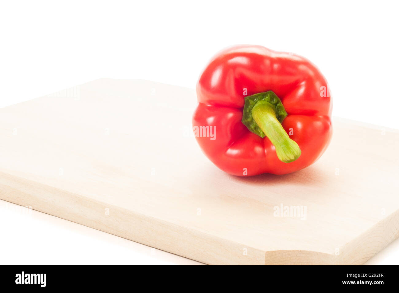 Big fat red pepper on wooden plate and white background Stock Photo - Alamy
