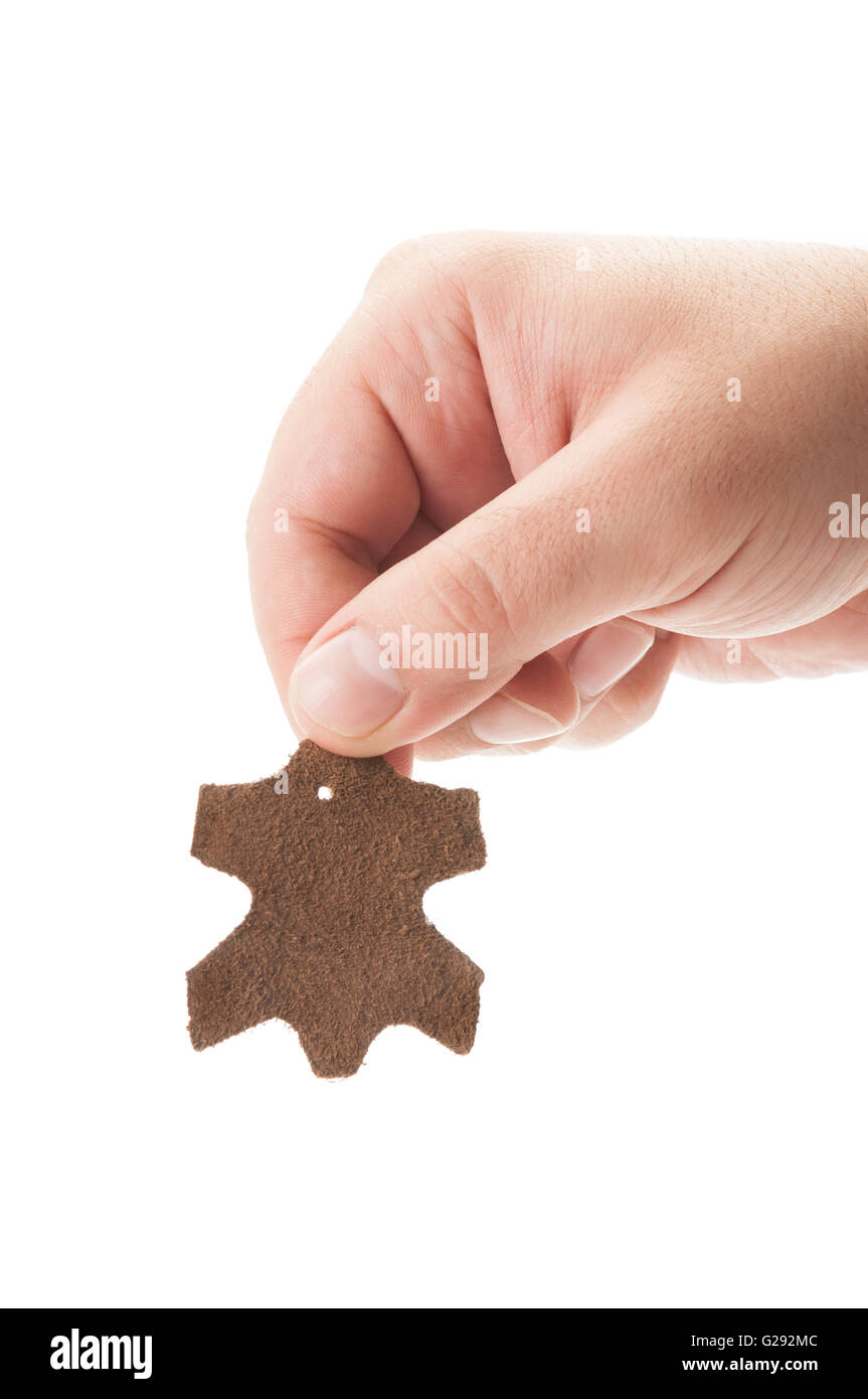 Hand holding a real leather sign on white background Stock Photo - Alamy