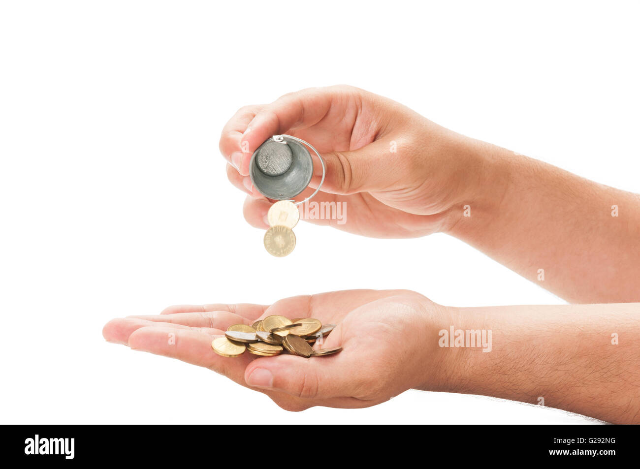 Pouring a bucket of coins from one hand to another on white background ...