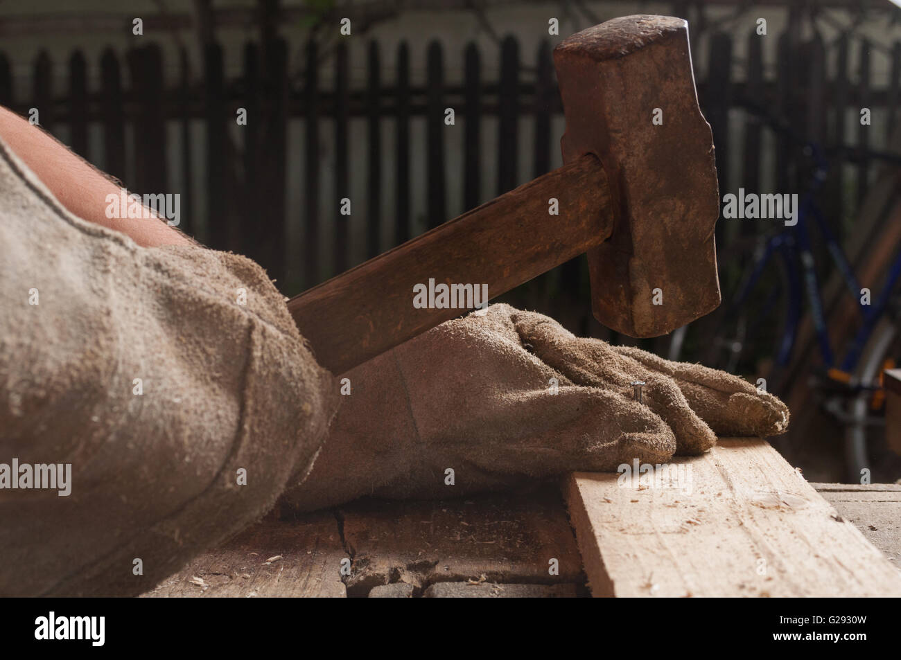 Carpenter knocking a nail into wood using hammer in his joinery Stock ...