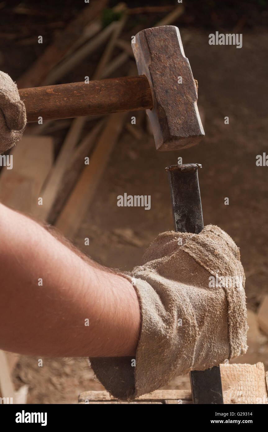 Worker hands using a hammer hitting a chisel Stock Photo - Alamy