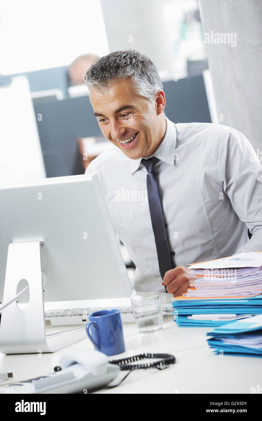 Happy mature business man working in office Stock Photo - Alamy