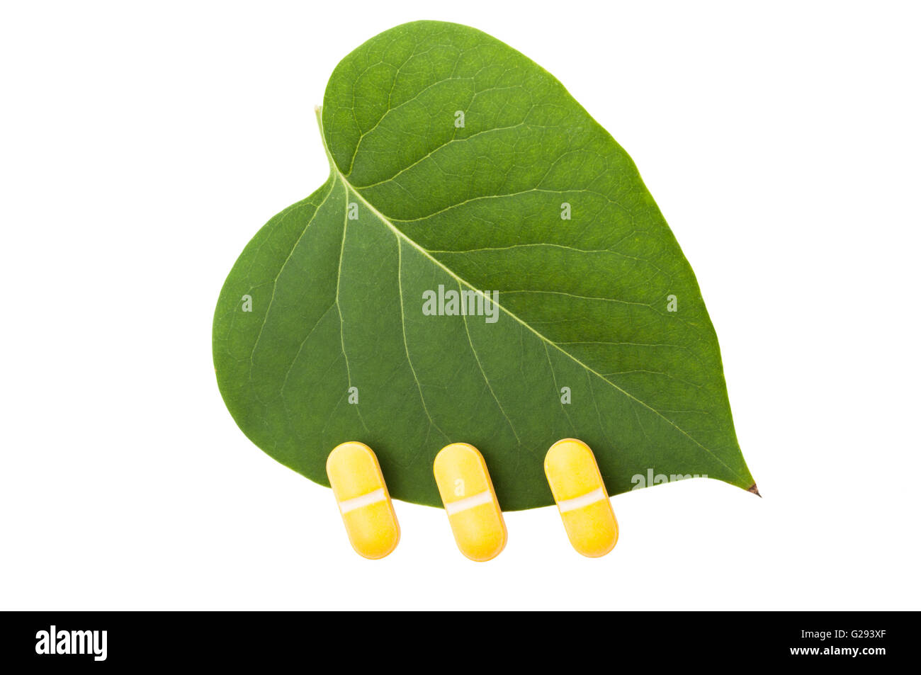 Three yellow pills on green leaf. Homeopathic concept isolated on white ...