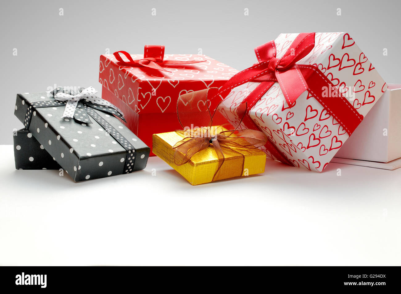 Group decorative gift boxes with ribbon and hearts printed on white ...