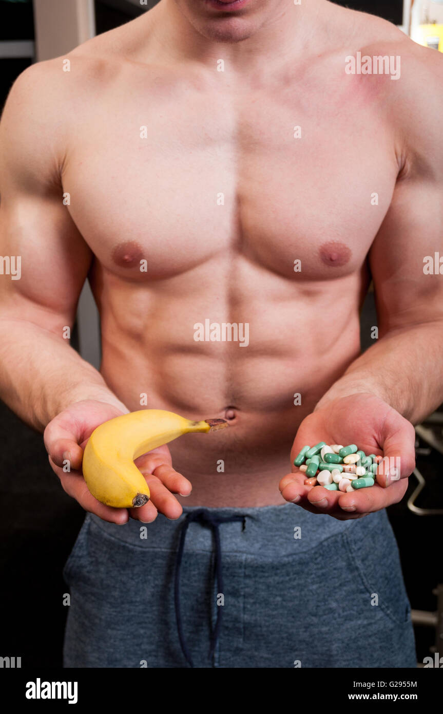 Muscle man choice between natural banana and a hand of pills Stock ...