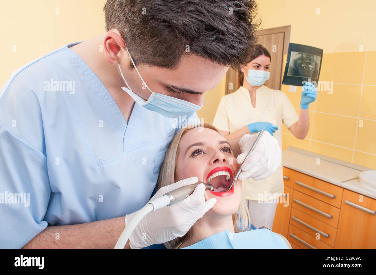 Dental team working on perfect teeth and examining xray Stock Photo - Alamy
