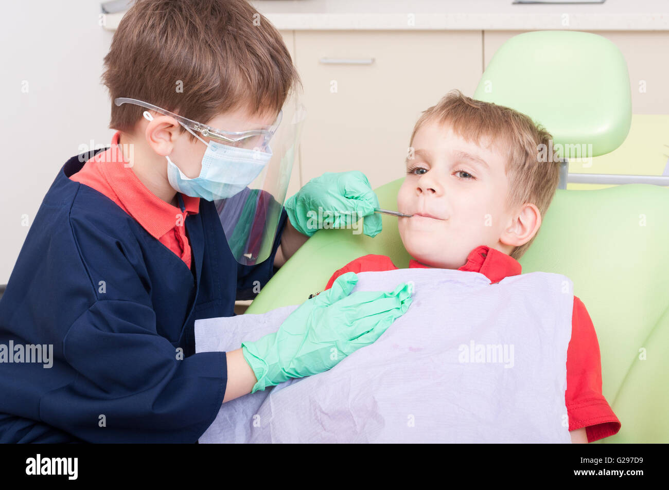 Kids acting as doctor and patient in dental office. Fearless boy ...