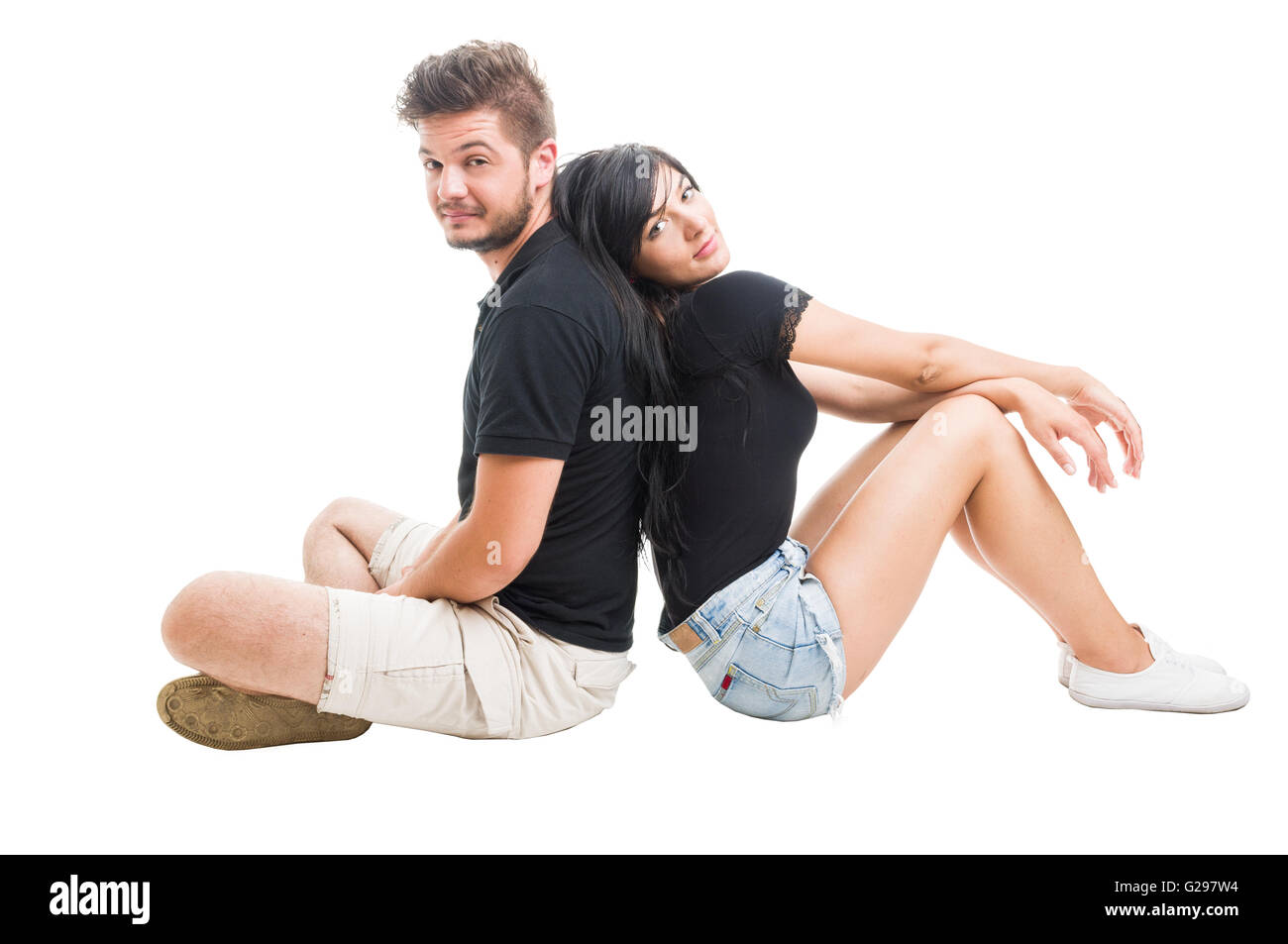 Happy couple sitting back to back or behind each other on white studio ...