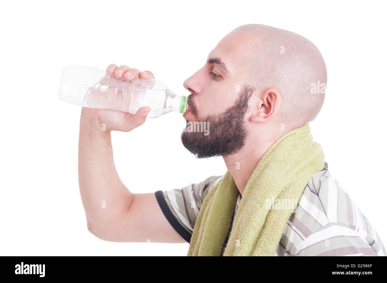 Thirsty man drinking cold water with towel arround his neck isolated on ...