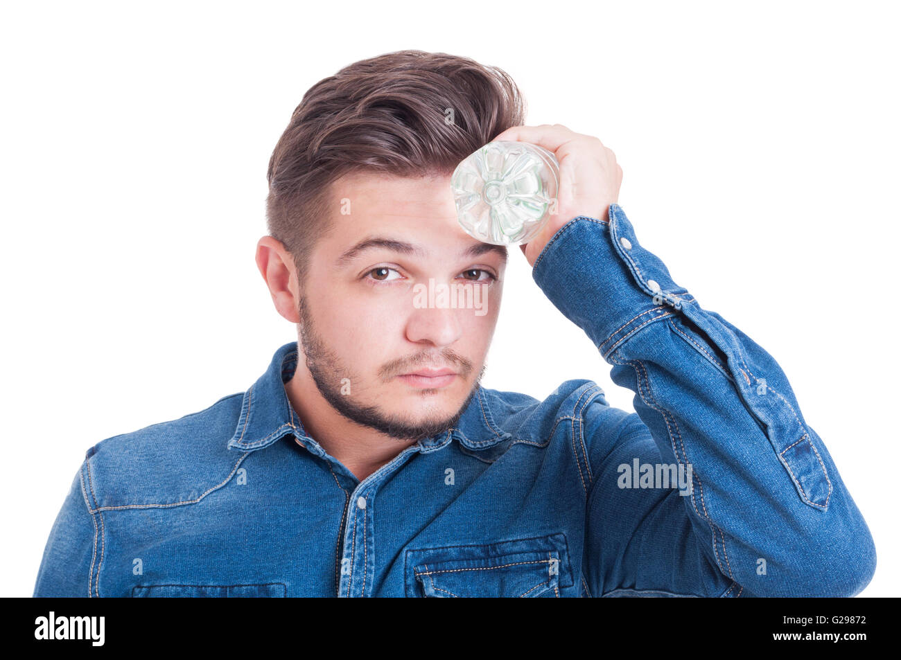 Man cooling his forehead with cold water bottle as summer heat concept ...