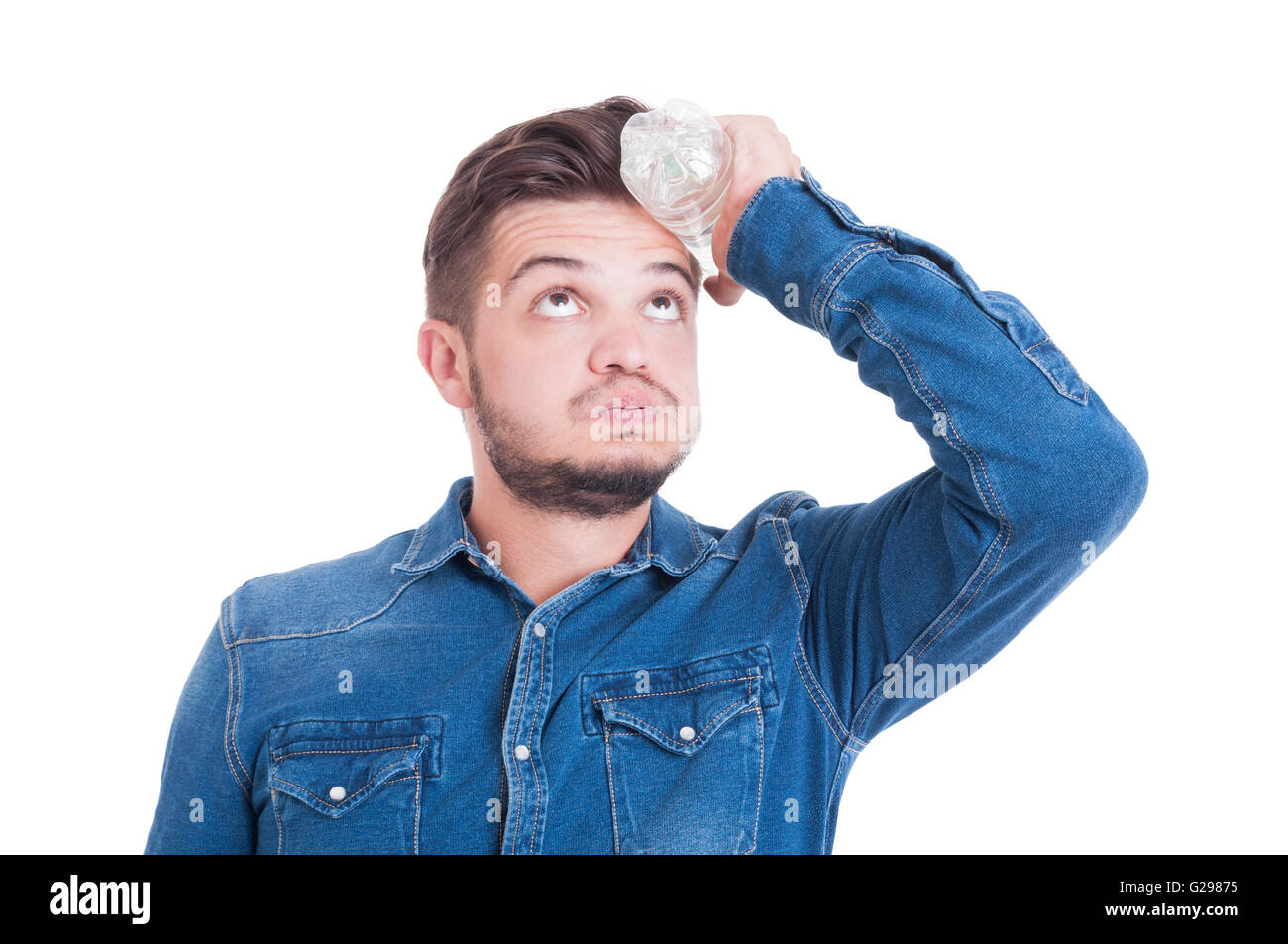 Man cooling his head with cold water bottle as summer heat concept ...