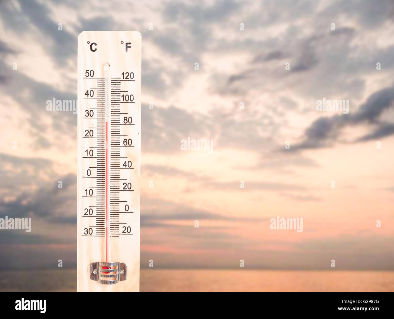 Thermometer on ocean or sea sunset background as hot summer days ...