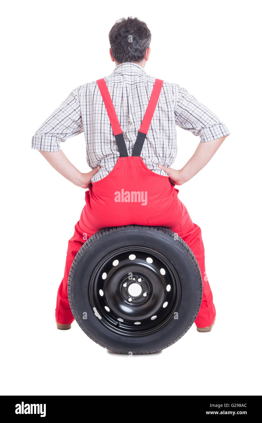 Mechanic sitting on tire with the back to the camera isolated on white ...