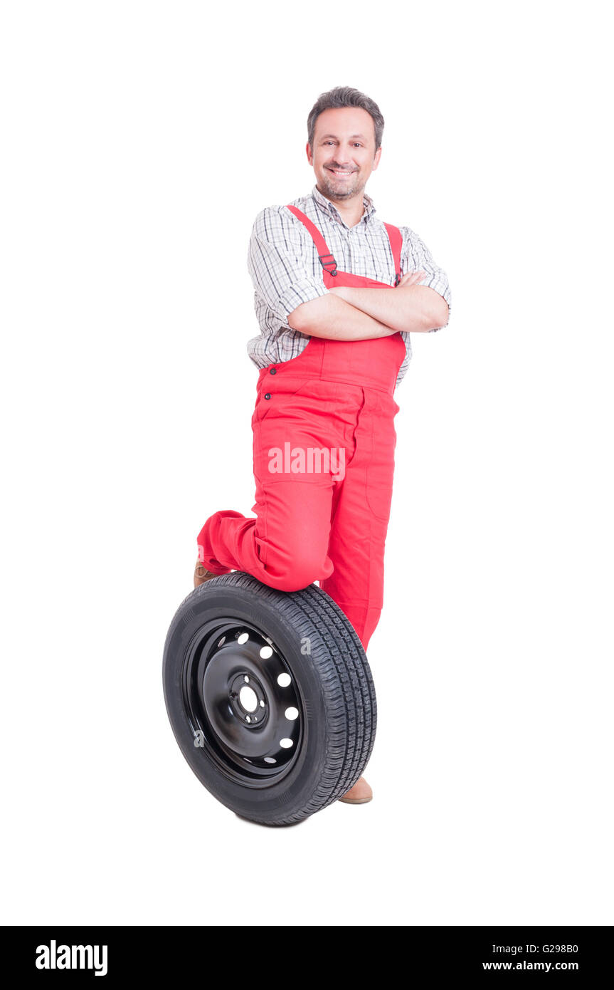 Confident mechanic resting foot on car wheel and arms crossed Stock ...