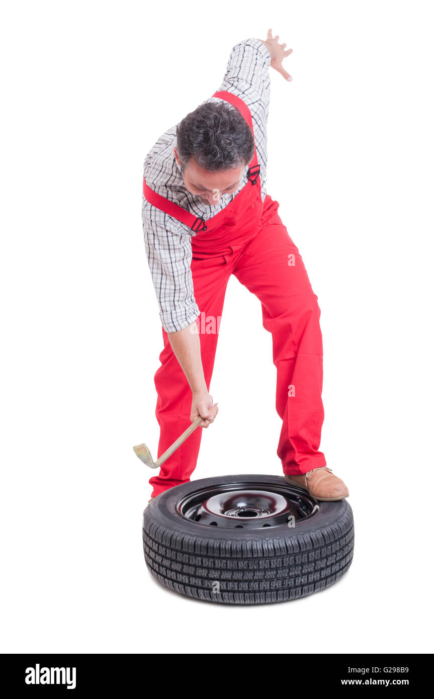 Angry mechanic changing tire getting mad and hitting it Stock Photo - Alamy
