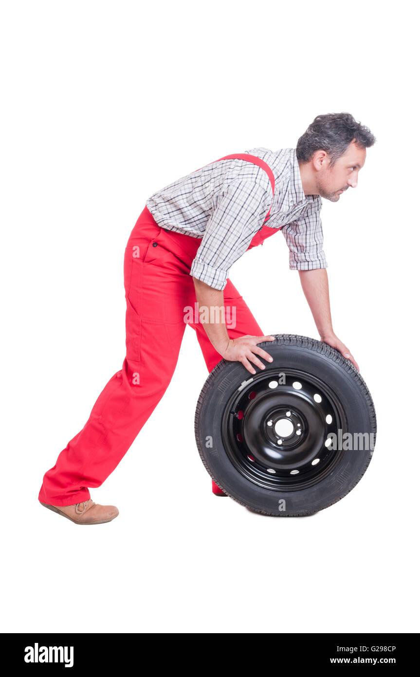 Side view of a mechanic pushing a new car wheel isolated on white Stock ...