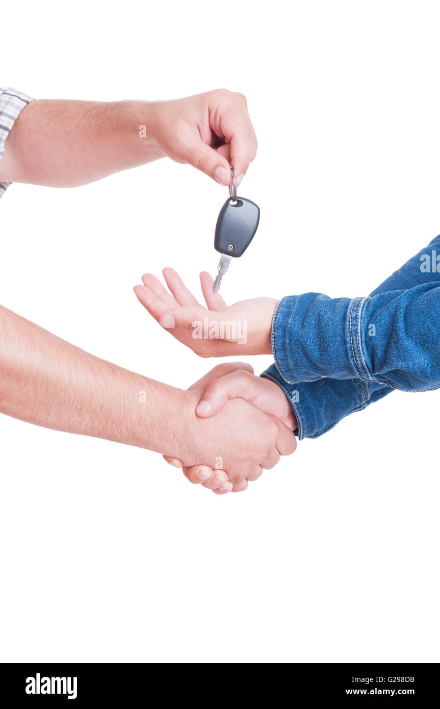 Mechanic or car dealer handing key to customer with handshake concept ...