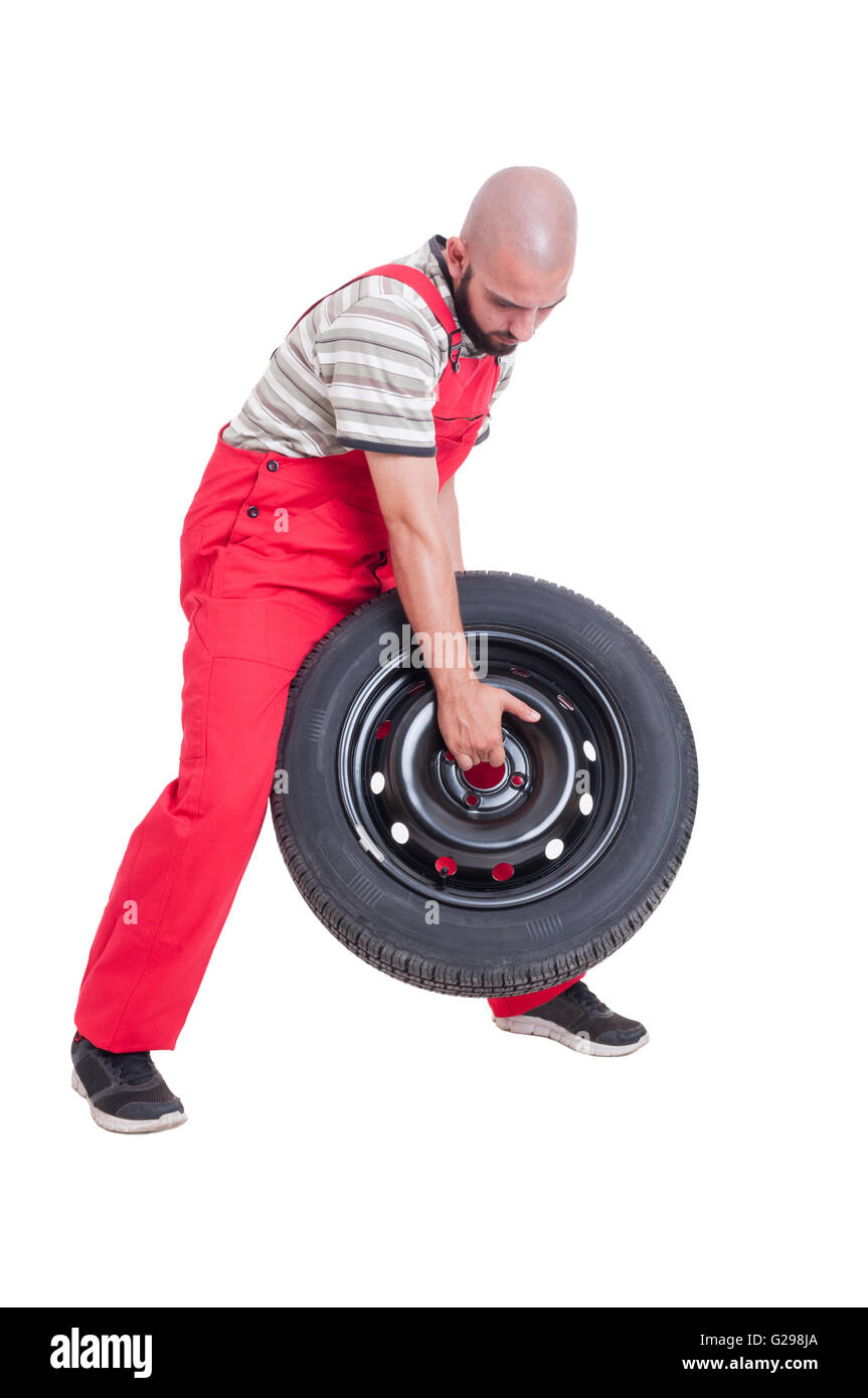 Mechanic lifting heavy car wheel isolated on white Stock Photo - Alamy