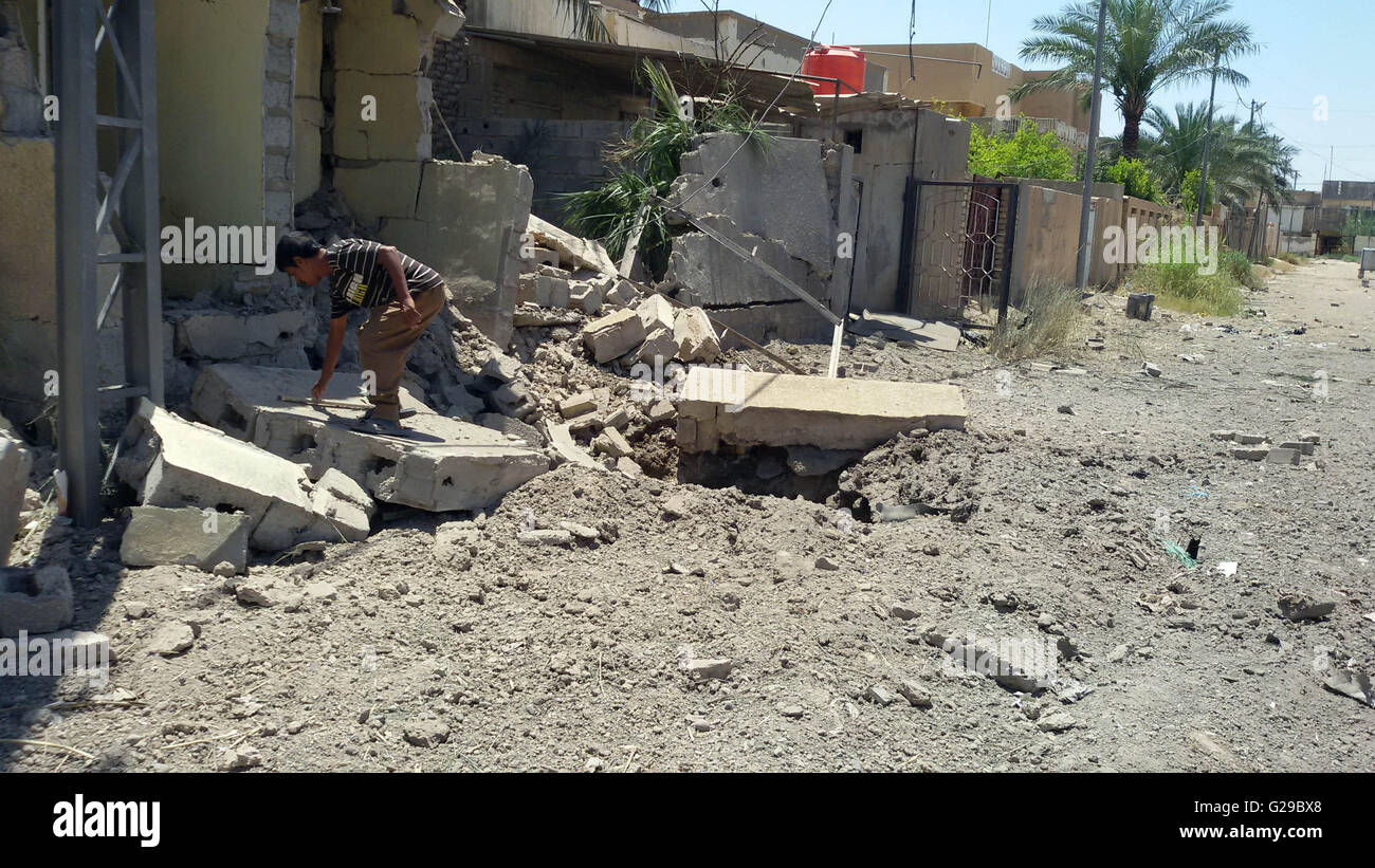 Fallujah, Iraq. 26th May, 2016. A person checks a destroyed building ...