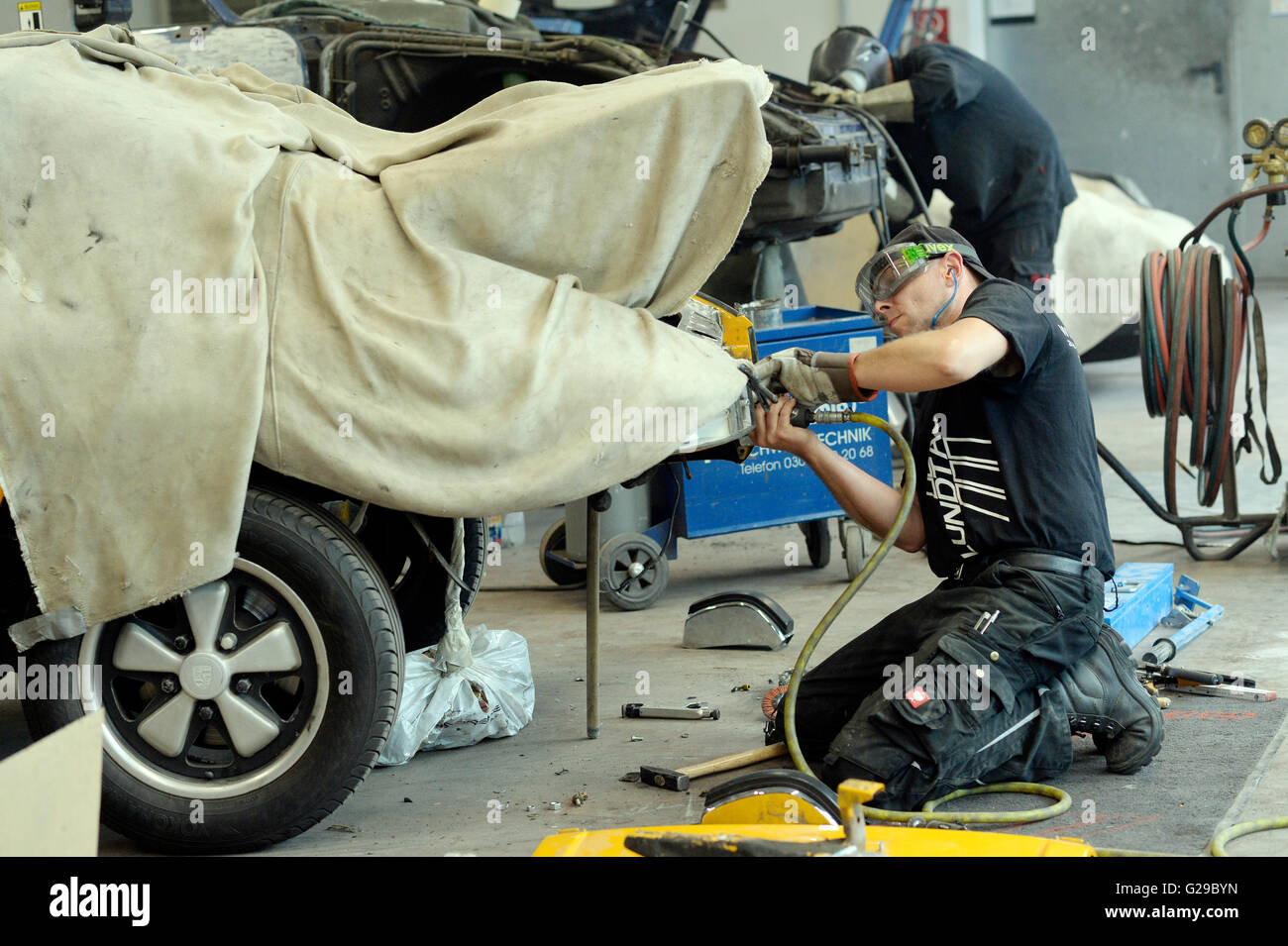 Berlin, Germany. 23rd May, 2016. An coachbuilder repairs a car in an ...