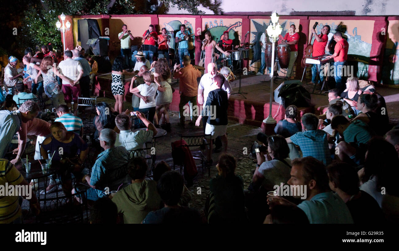 Cuban musicians in a group playing and singing salsa for locals and ...