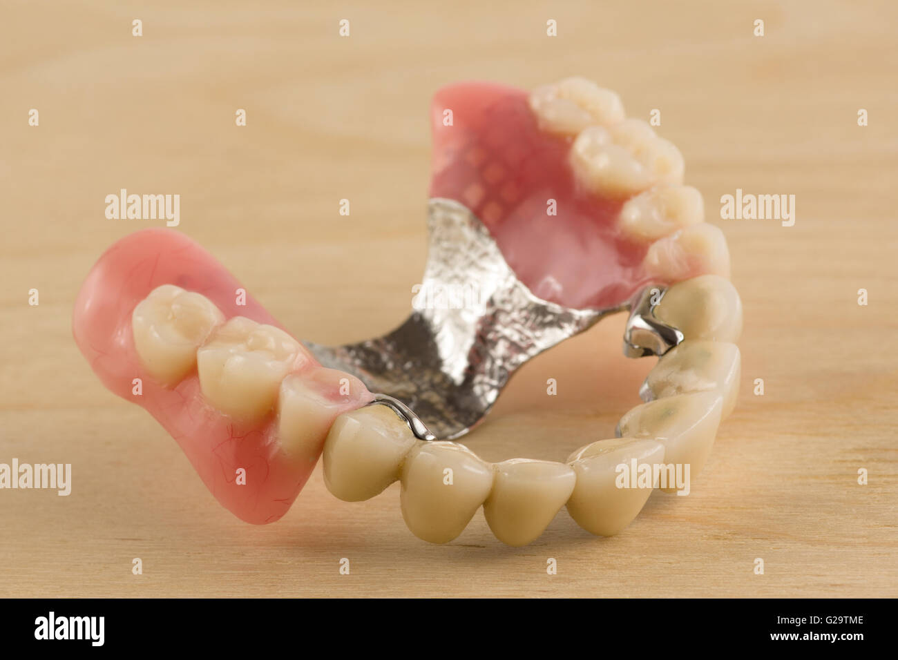 new dentures with metal-ceramic crowns lie on a wooden table Stock ...