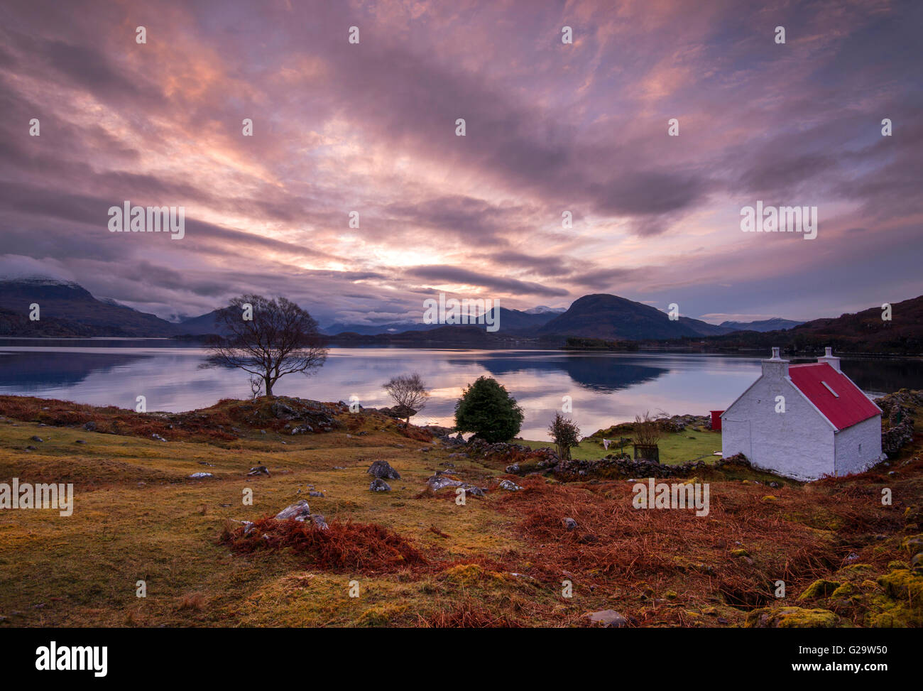 White cottage with a red roof, on the banks of Loch Shieldaig at ...