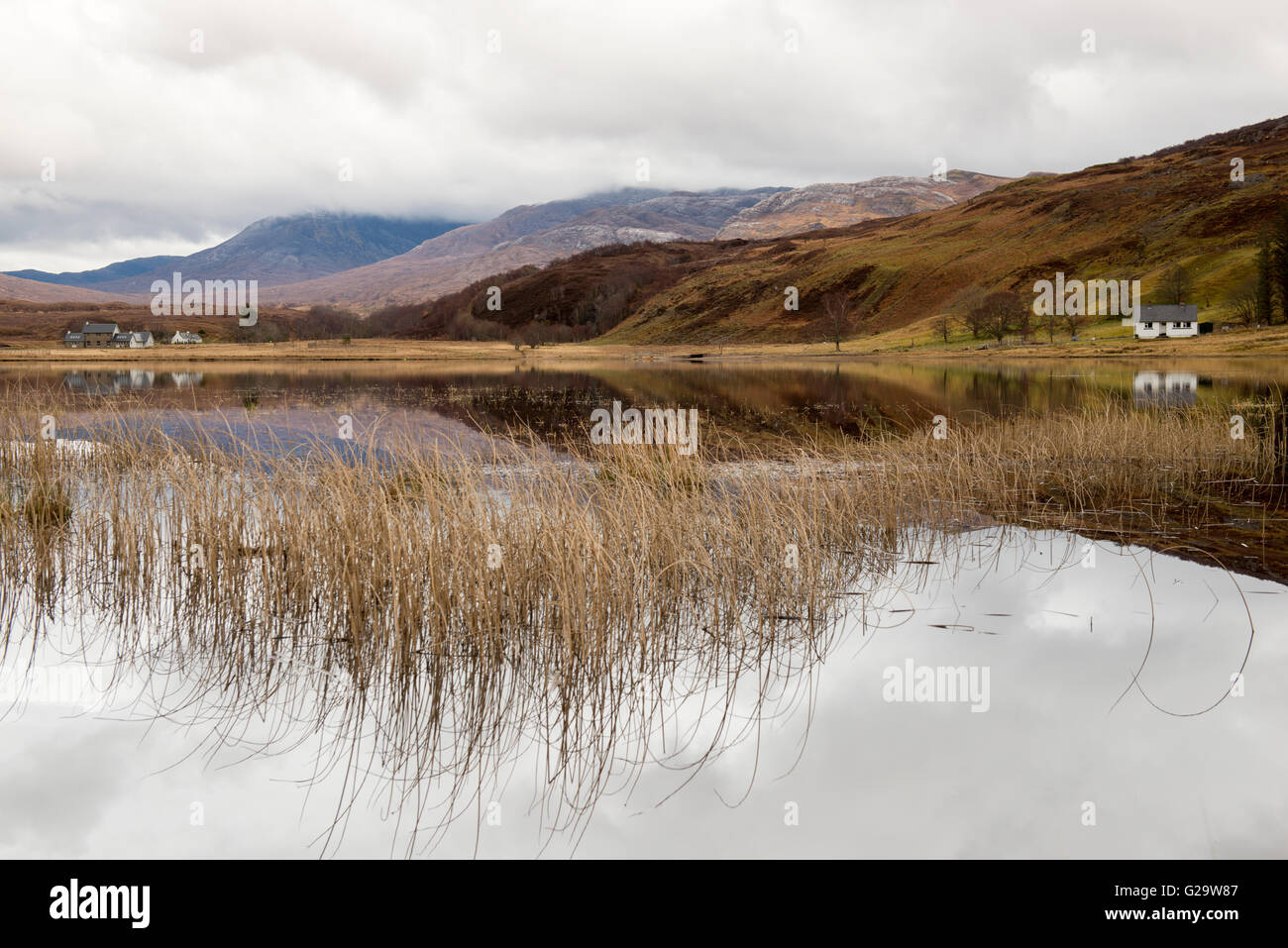 Mirror calm reflections on Loch Damh on the Lochcarron Estate in Wester ...