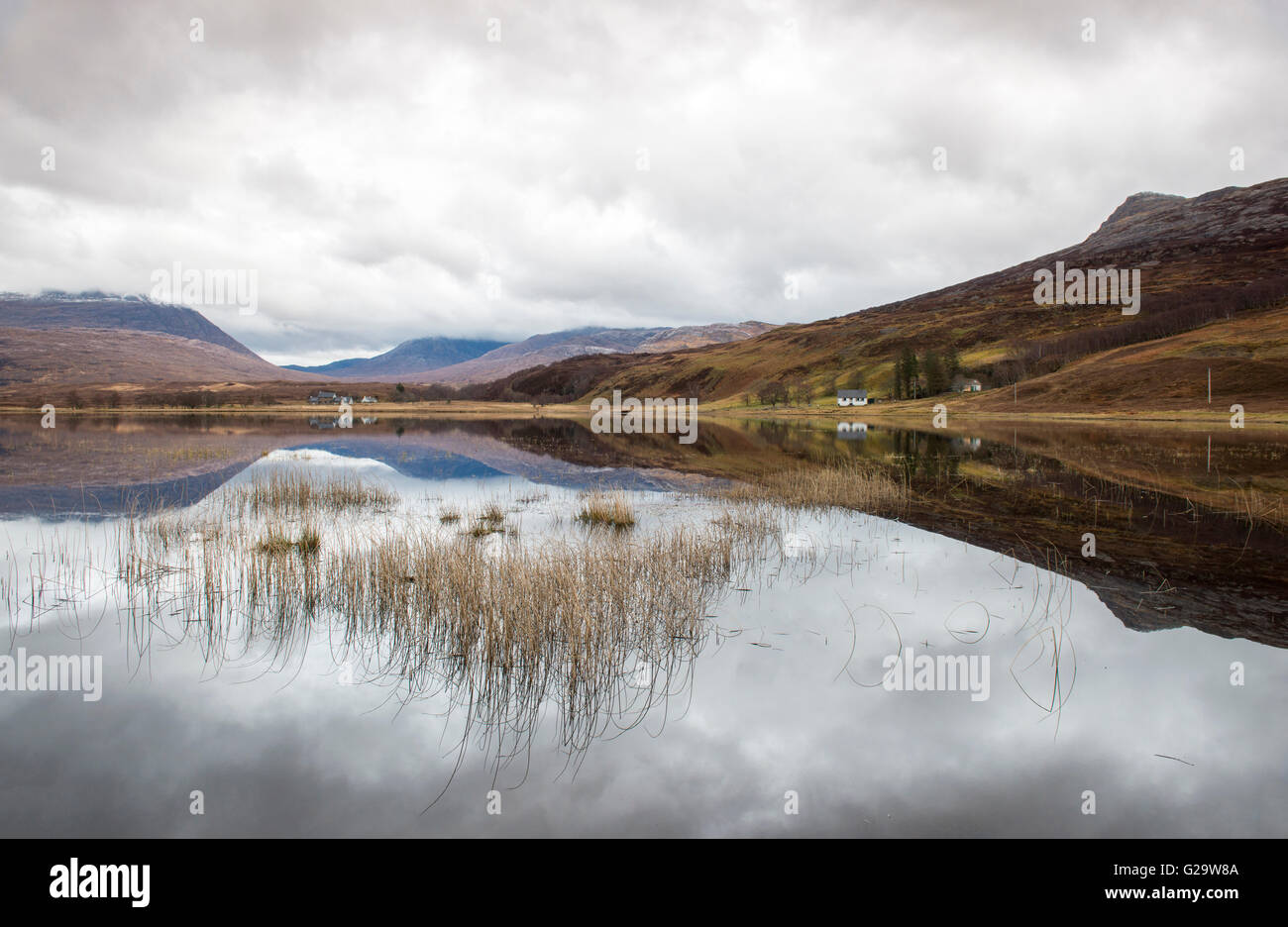 Mirror calm reflections on Loch Damh on the Lochcarron Estate in Wester ...