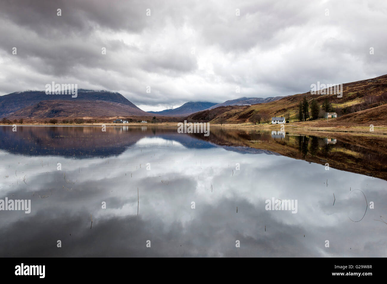 Mirror calm reflections on Loch Damh on the Lochcarron Estate in Wester ...