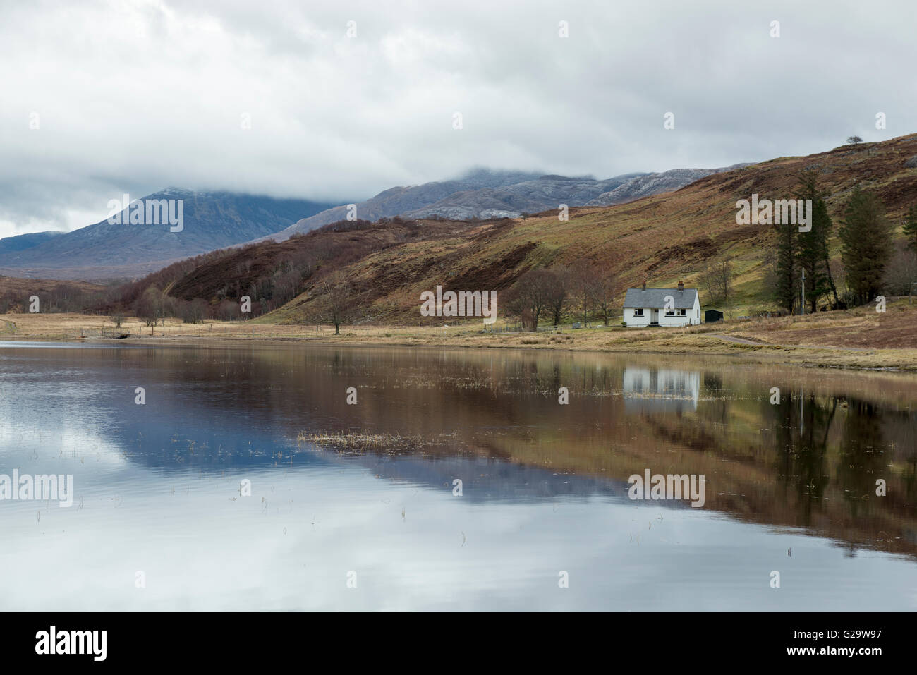 Mirror calm reflections on Loch Damh on the Lochcarron Estate in Wester ...
