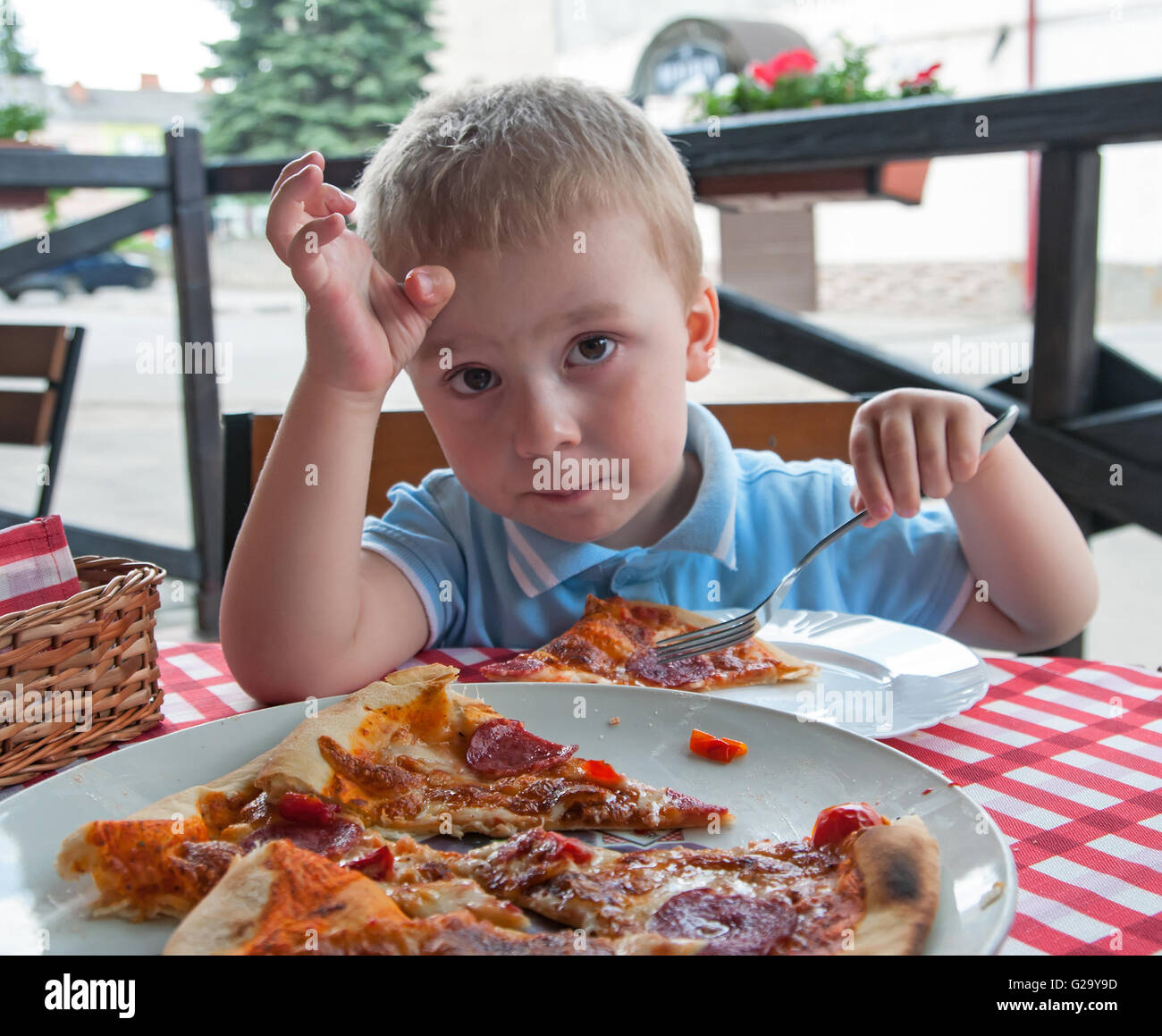 Sweet adorable child, boy, eating pizza at a restaurant Stock Photo - Alamy