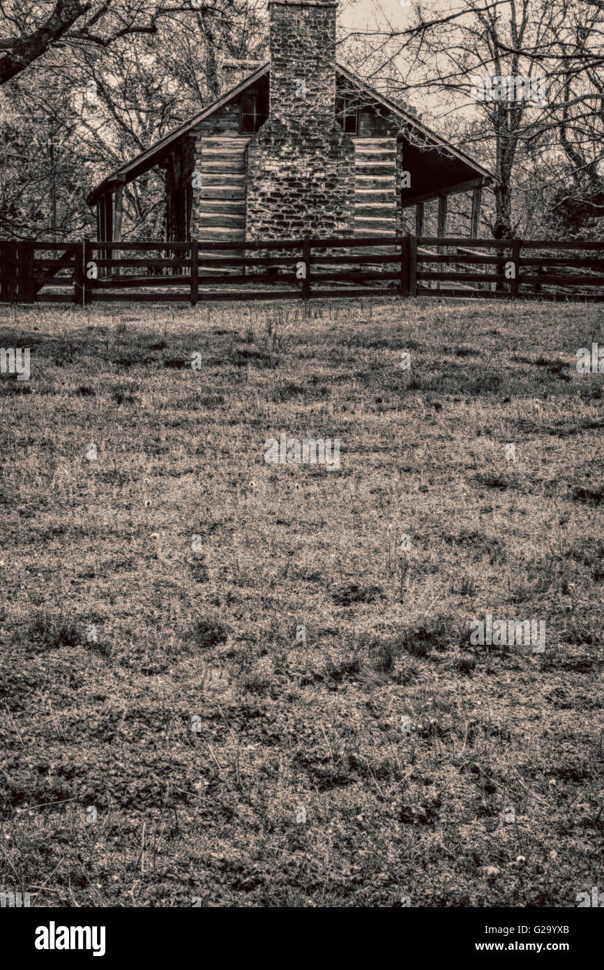 A charming rustic log cabin with front porch and seats in a 19th ...