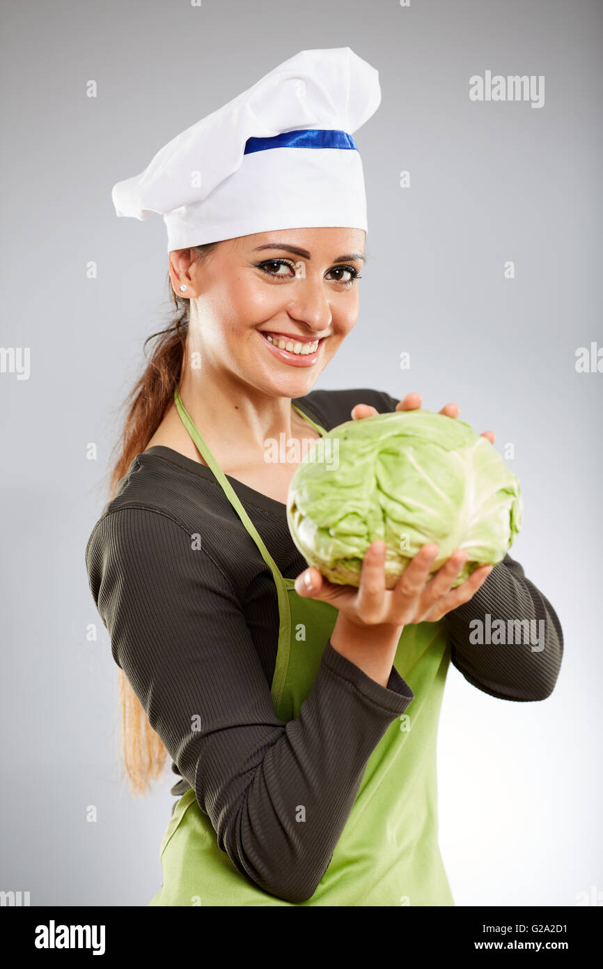 Attractive female cook holding a white cabbage Stock Photo - Alamy