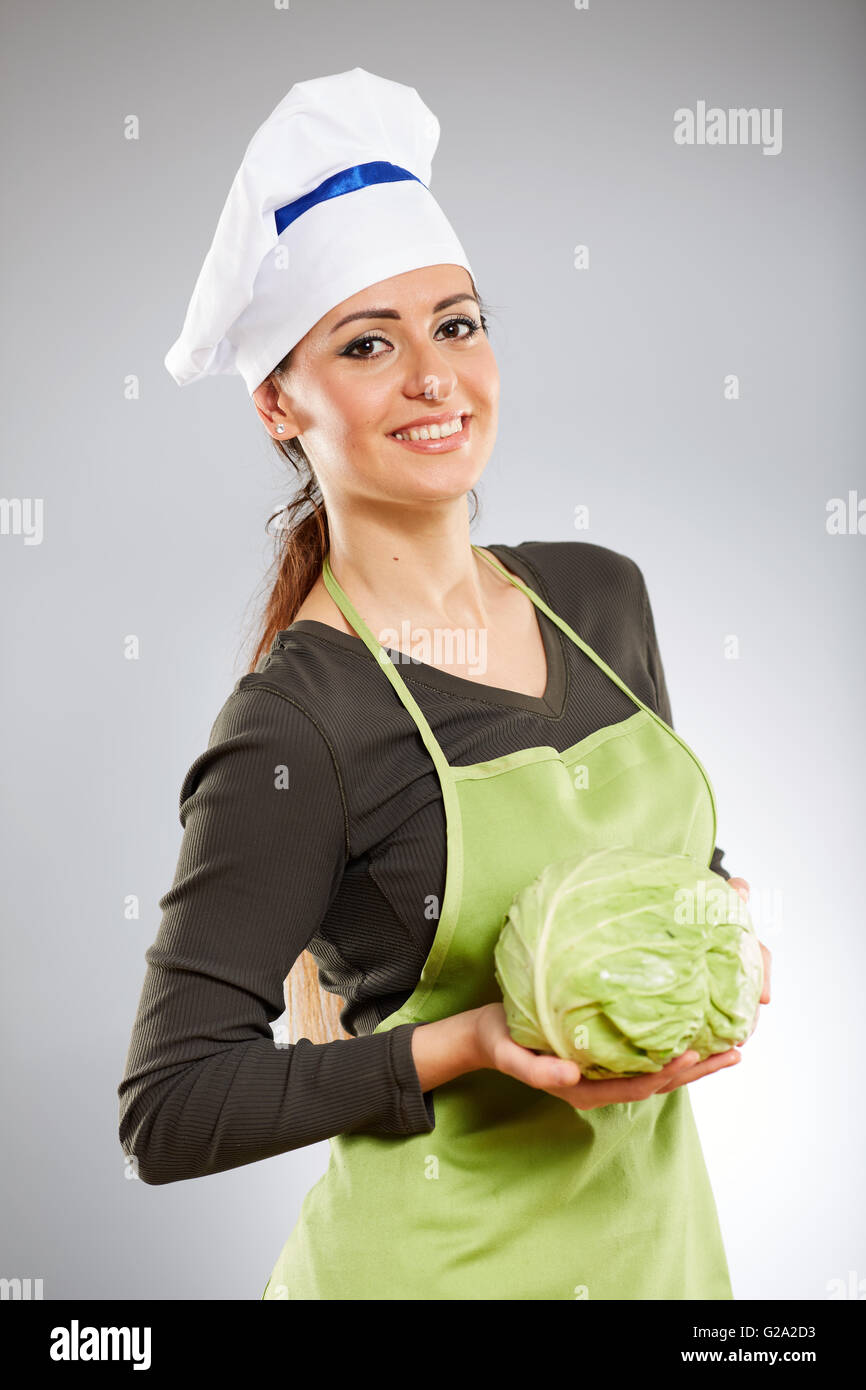 Attractive female cook holding a white cabbage Stock Photo - Alamy