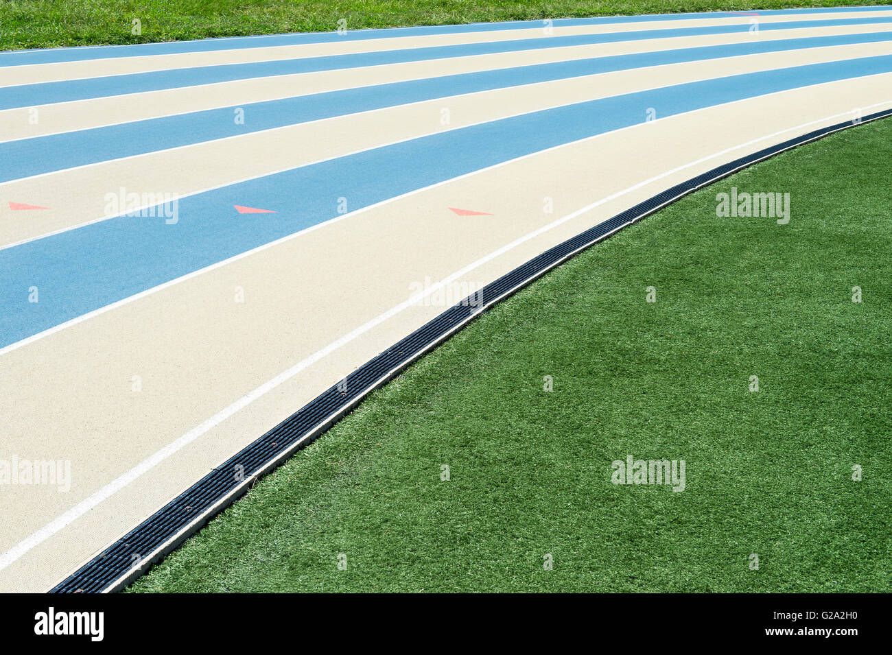 Modern running track background in blue and tan with green grass full ...