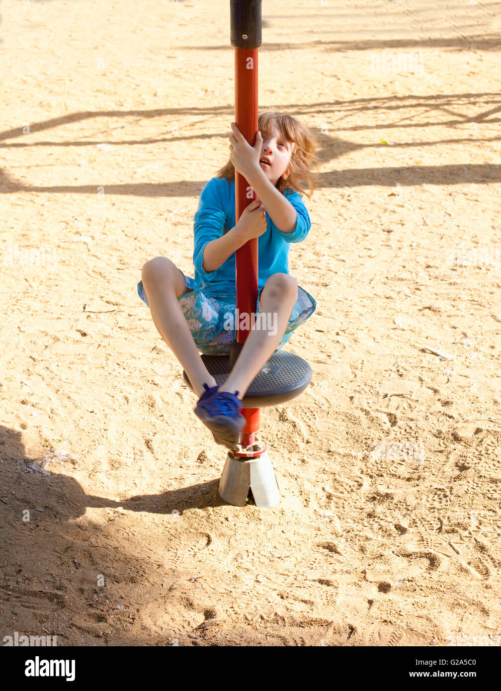 Boy with Blond Hair Spinning on a Pole at Playground Stock Photo - Alamy