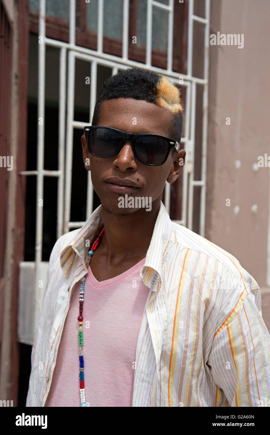Portrait of a young Cuban man wearing sunglasses and with crazy dyed ...