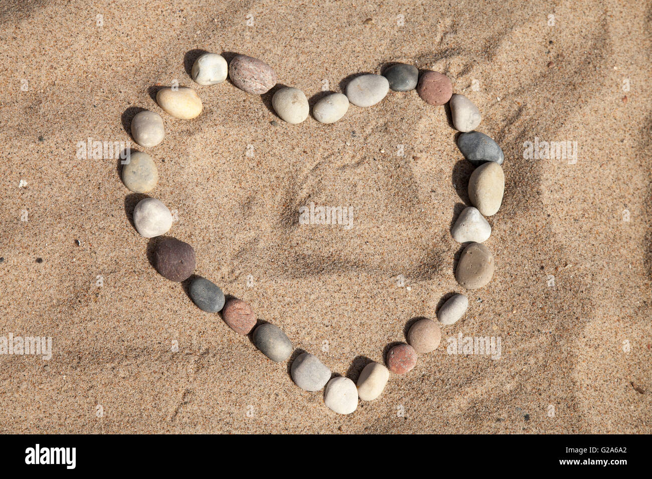 Heart stone in sand hi-res stock photography and images - Alamy