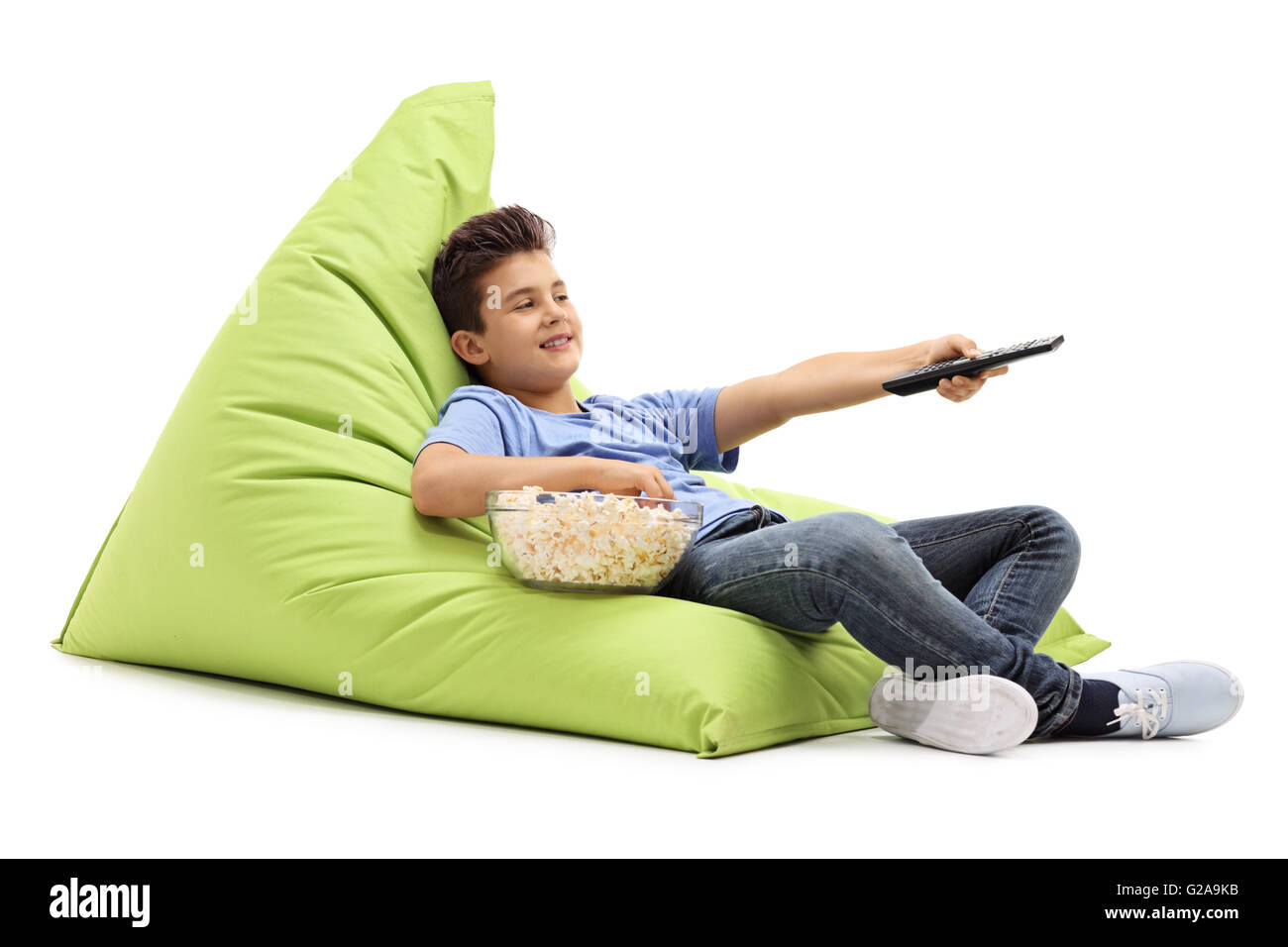Little kid changing channels on TV and eating popcorn seated on a green ... Little kid changing channels on TV and eating popcorn seated on a green ...