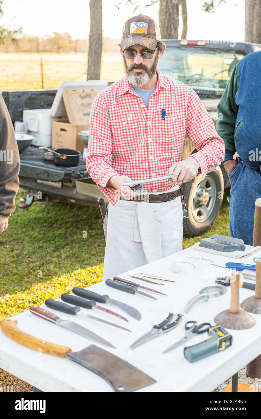 A butcher sharpens his knives before slaughtering a hog for a Cajun ...