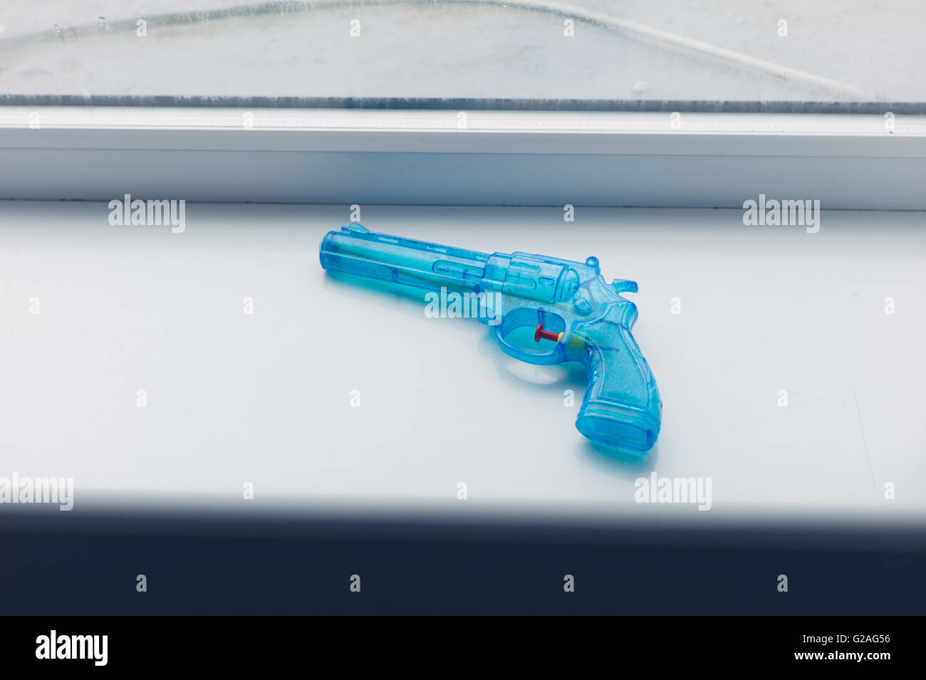 A blue toy gun on a window sill Stock Photo - Alamy