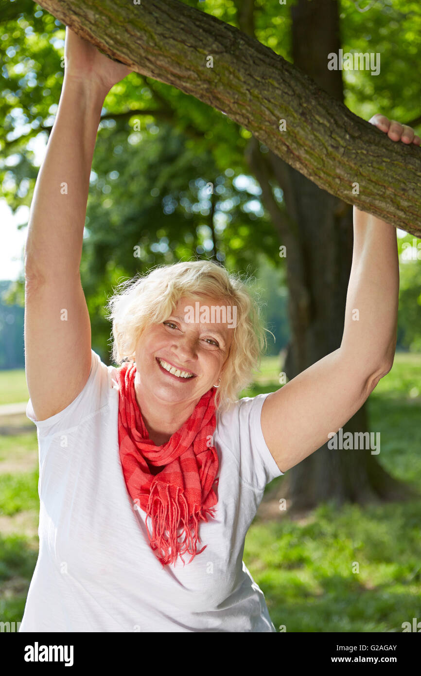 Happy senior woman standing in a summer garden under a tree Stock Photo ...