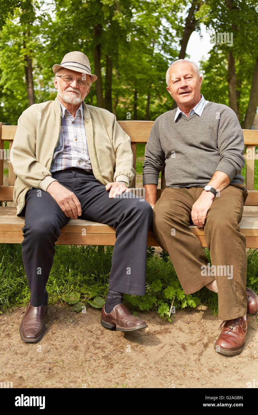 Two senior men sitting on a park bench in summer Stock Photo - Alamy