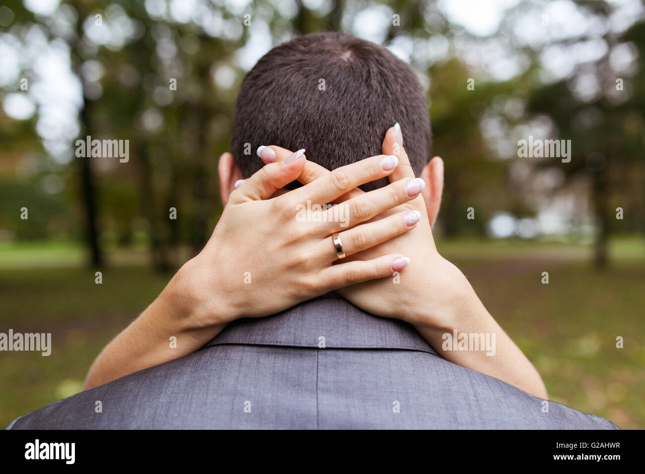 Women's arms around a man's head in the park on a date Stock Photo - Alamy