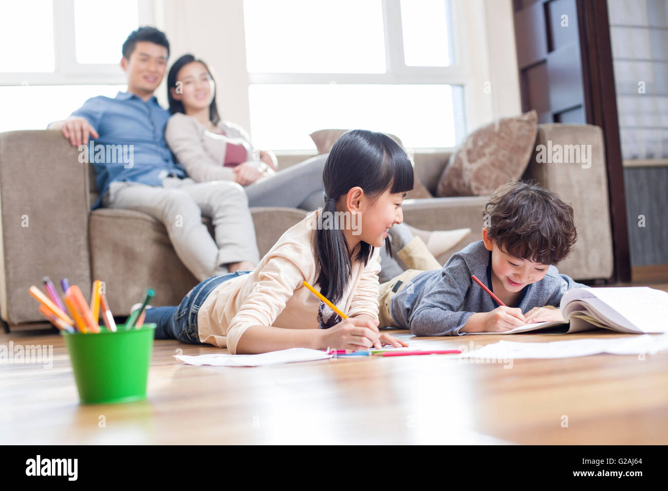 Happy siblings studying together at home Stock Photo - Alamy
