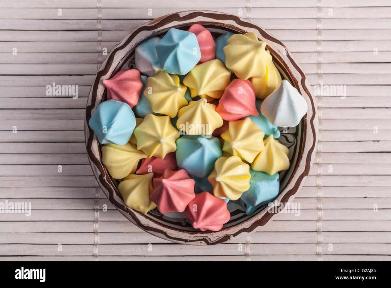 Rainbow circle sweets on plate on white wood Stock Photo - Alamy