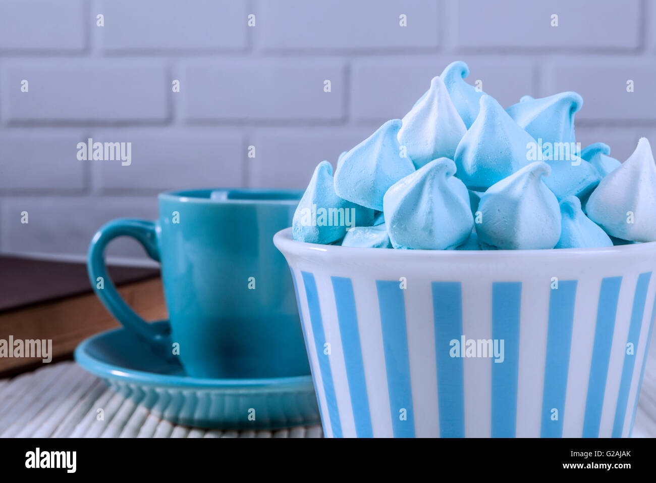 Blue Sweets and cup and white brick background Stock Photo - Alamy